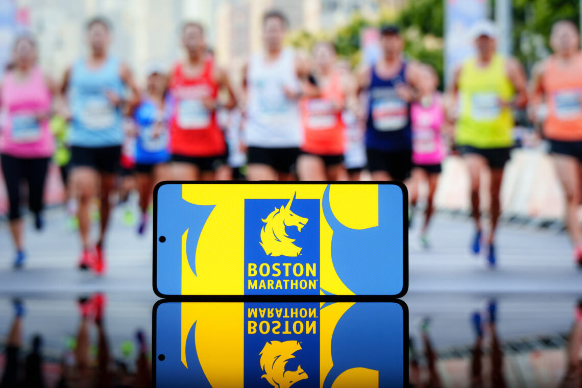 Smartphone displaying Boston Marathon logo with blurred runners in the ...